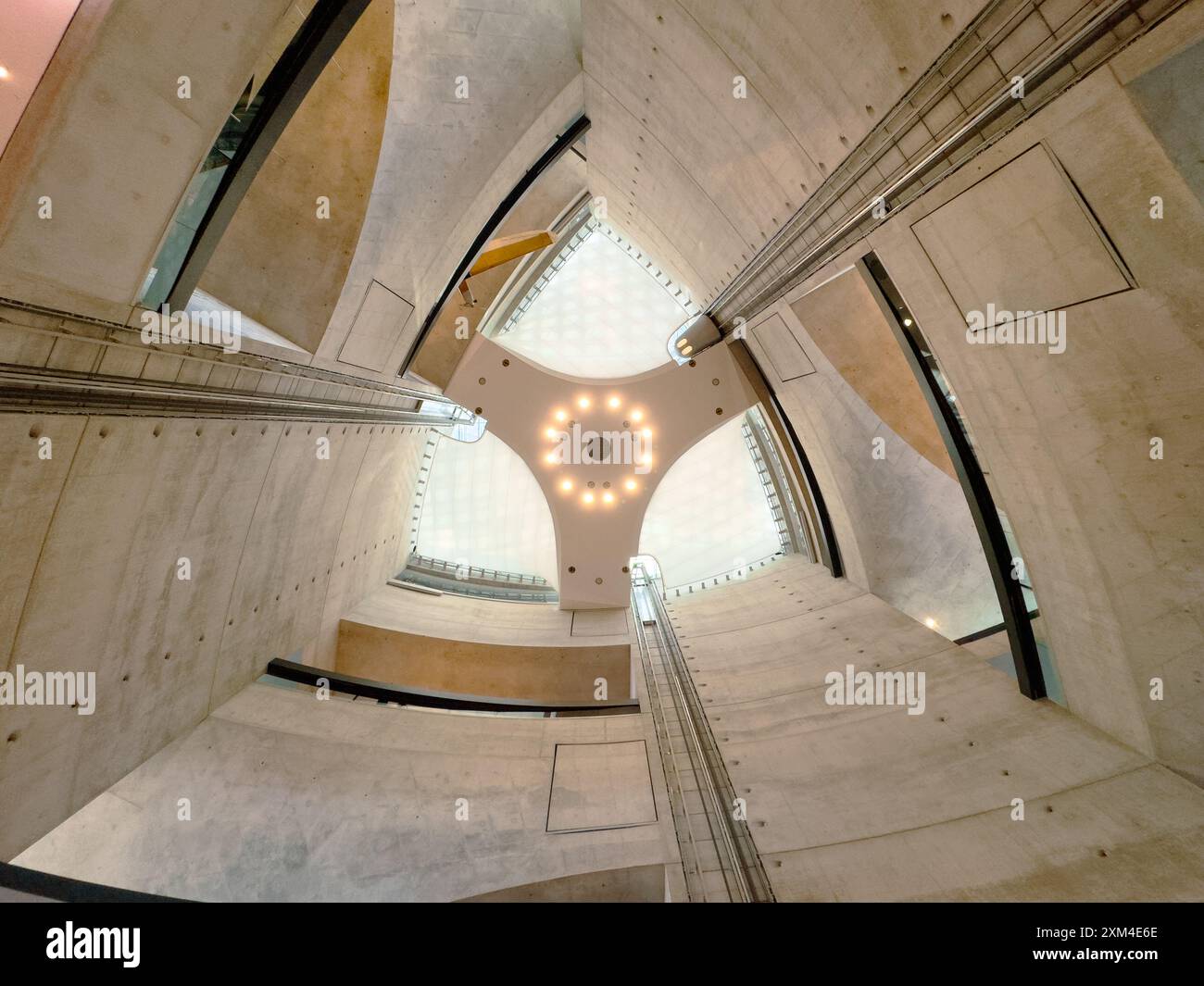 Looking up at a modern atrium featuring a geometric ceiling and ...