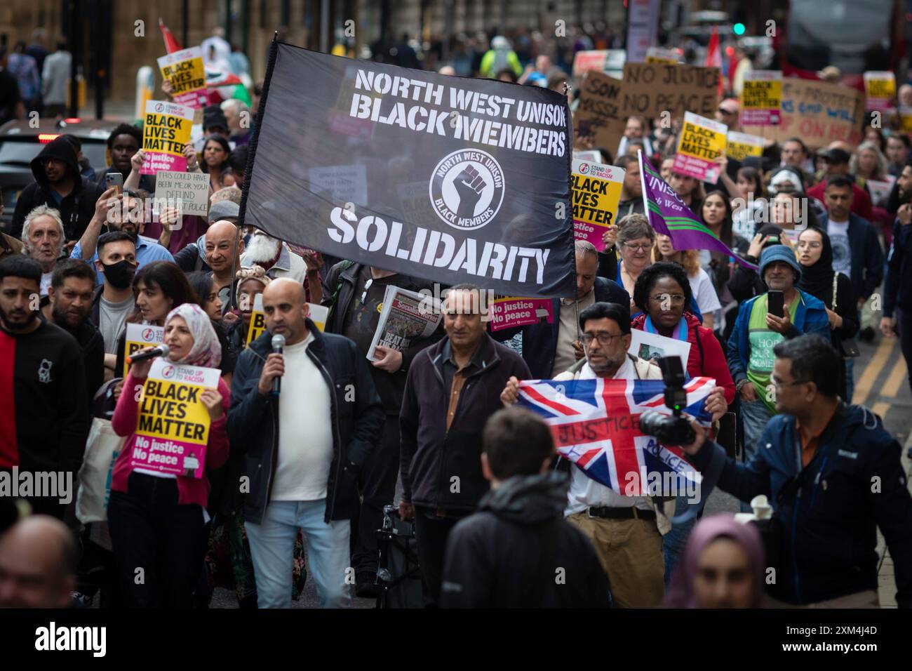 Manchester, UK. 25th July, 2024. People march through the city to ...