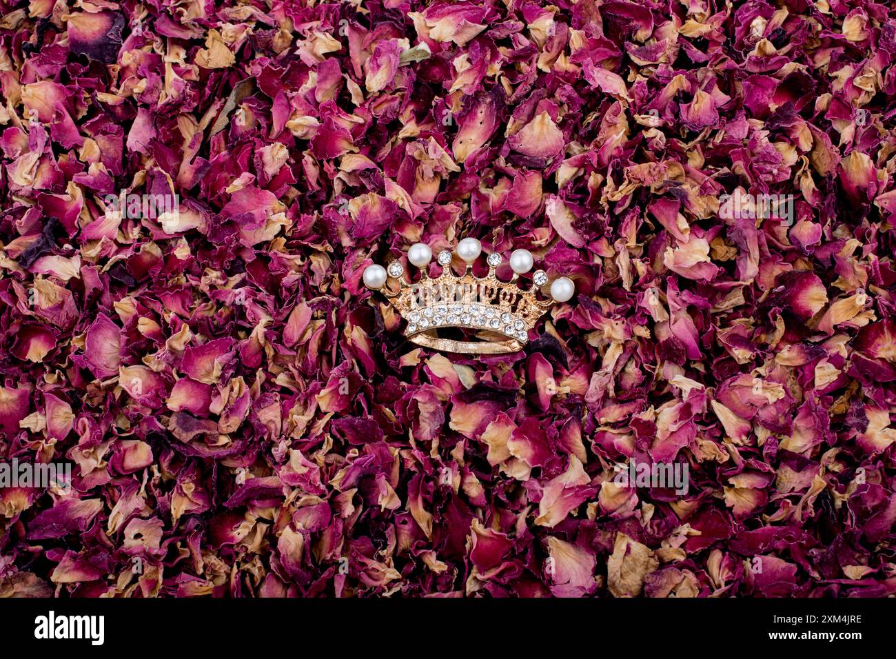 Crown is placed on background of dried rose petals Stock Photo - Alamy