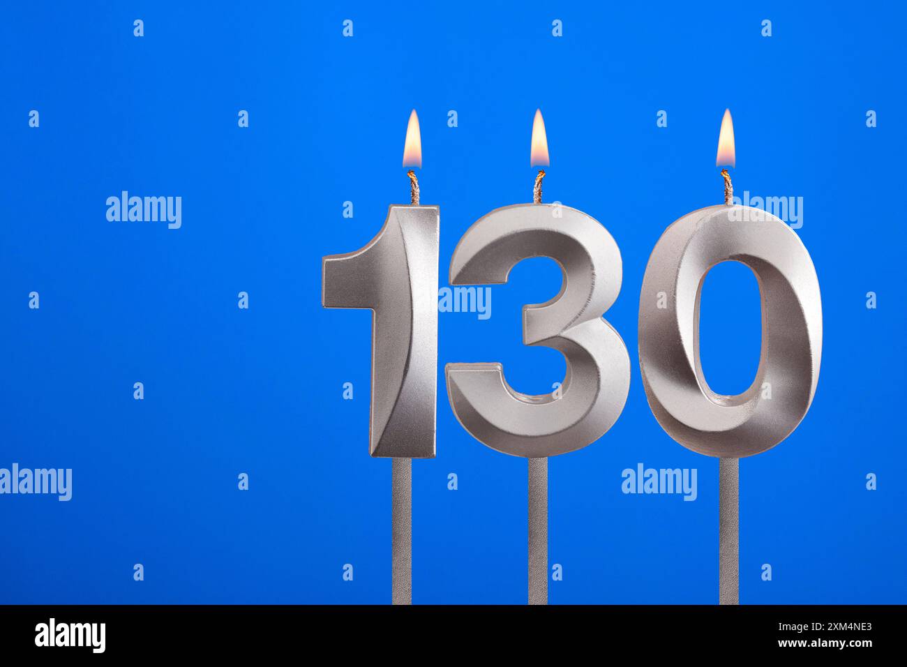Birthday number 130 - Candle lit on blue background Stock Photo - Alamy