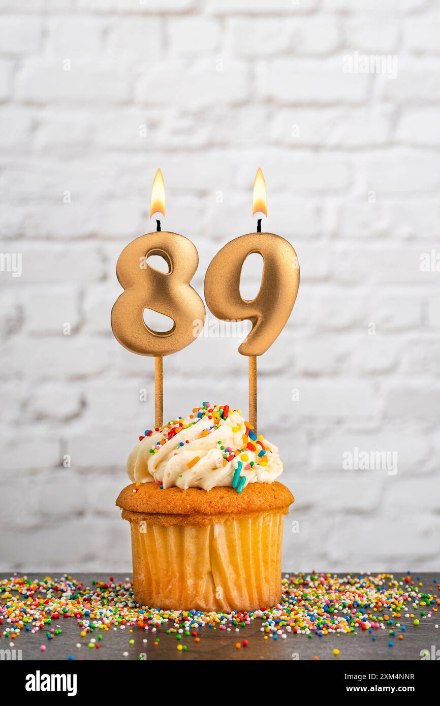 Golden birthday candle number 89 with cupcake - White block wall ...