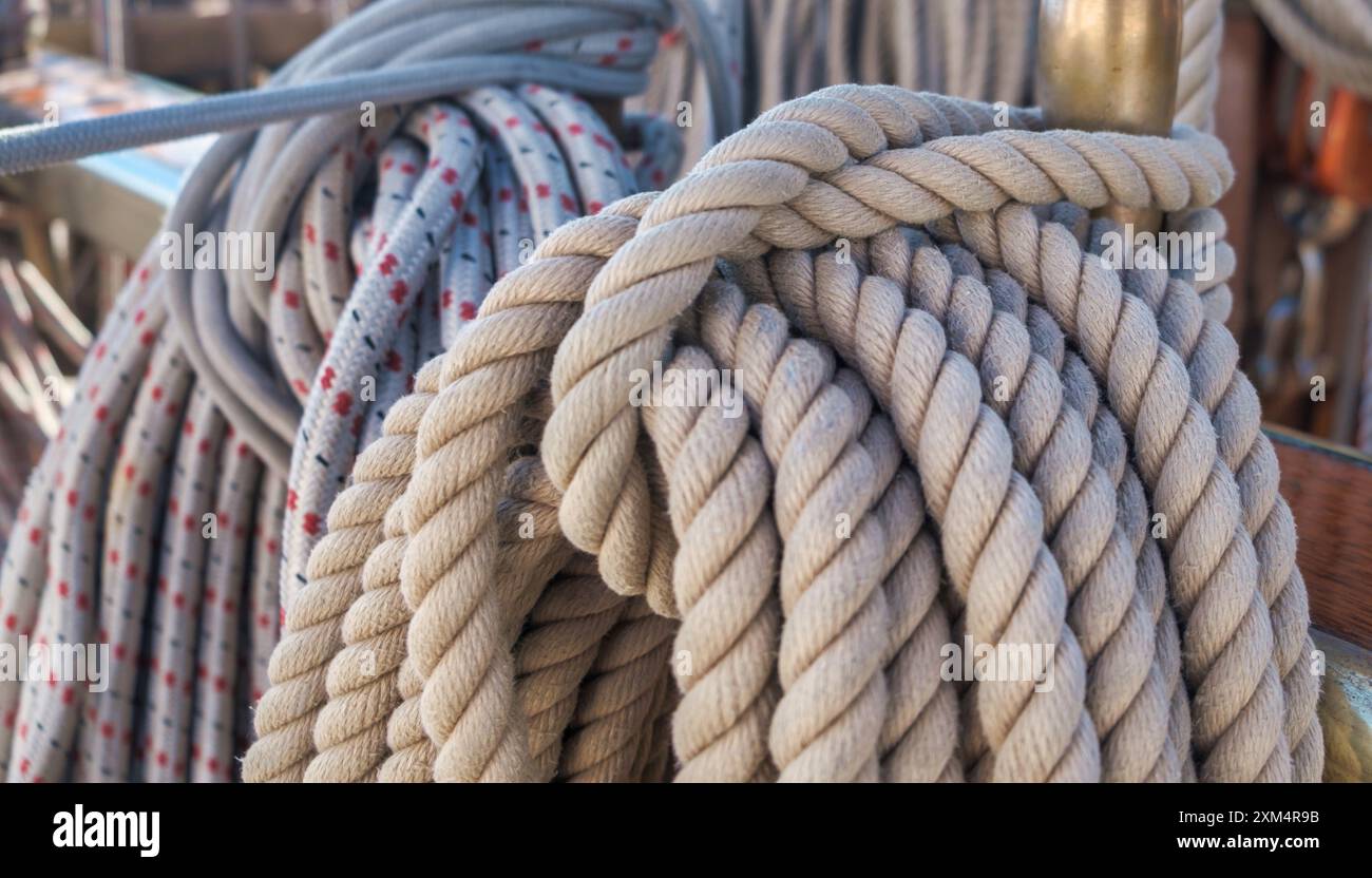 Maritime scene featuring a neatly coiled thick rope and another blurred ...