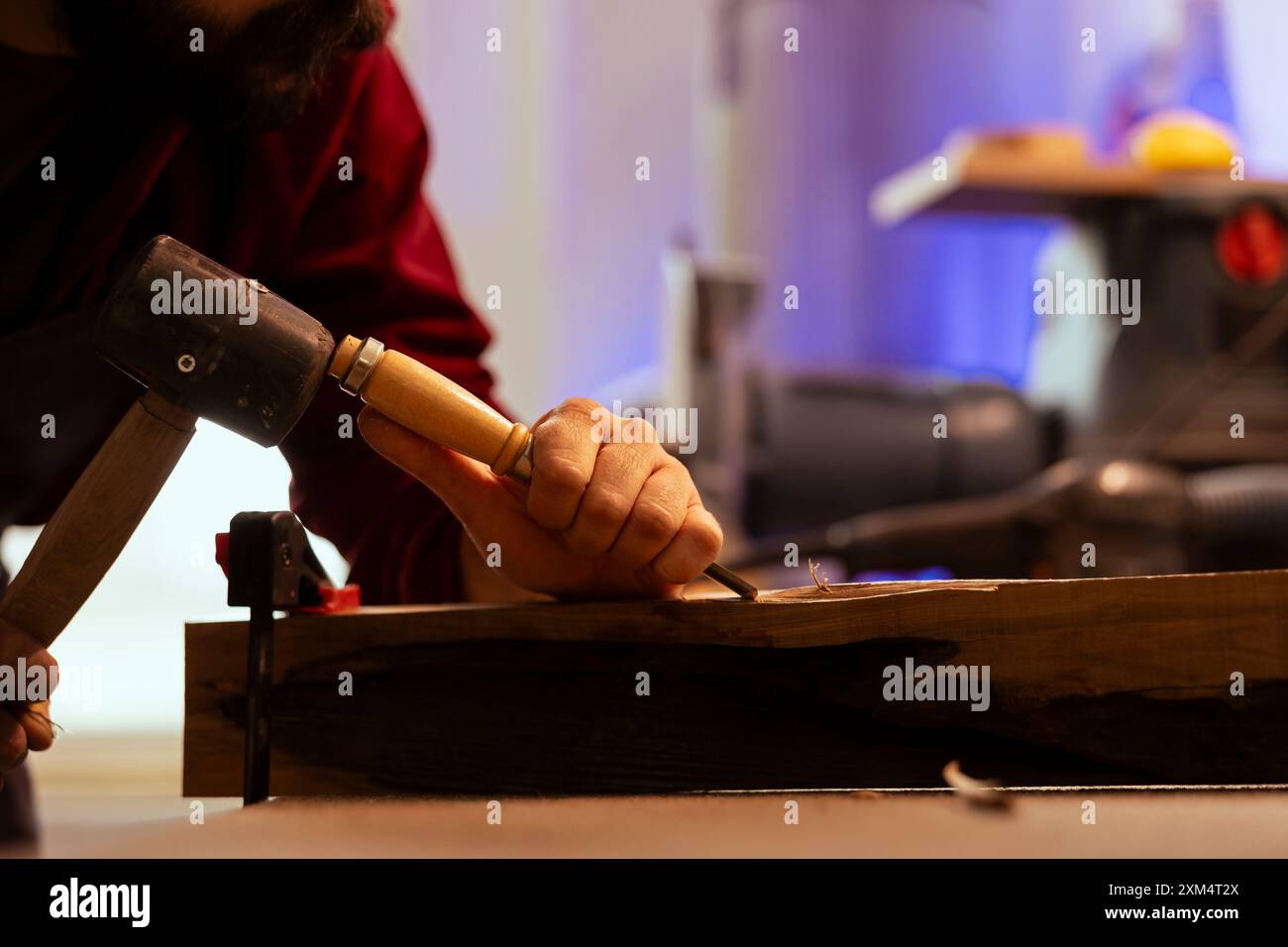 Sculptor shaping raw timber using chisel and hammer, creating wood art ...