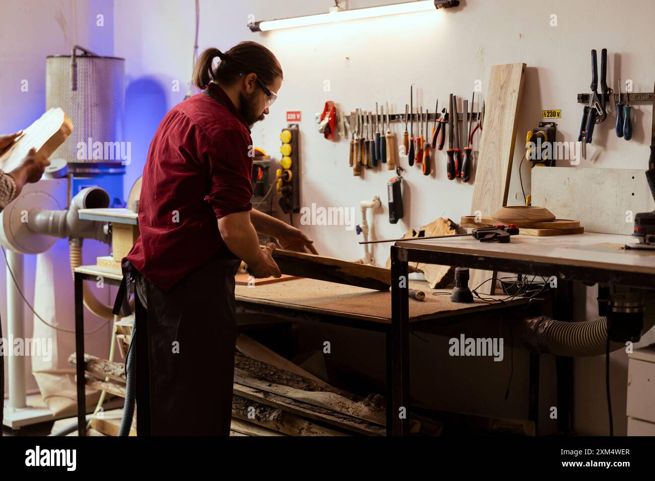 Man in carpentry shop wearing protection equipment while working with ...