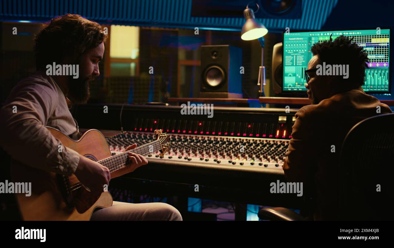 Professional musician tunes acoustic guitar hi-res stock photography ...
