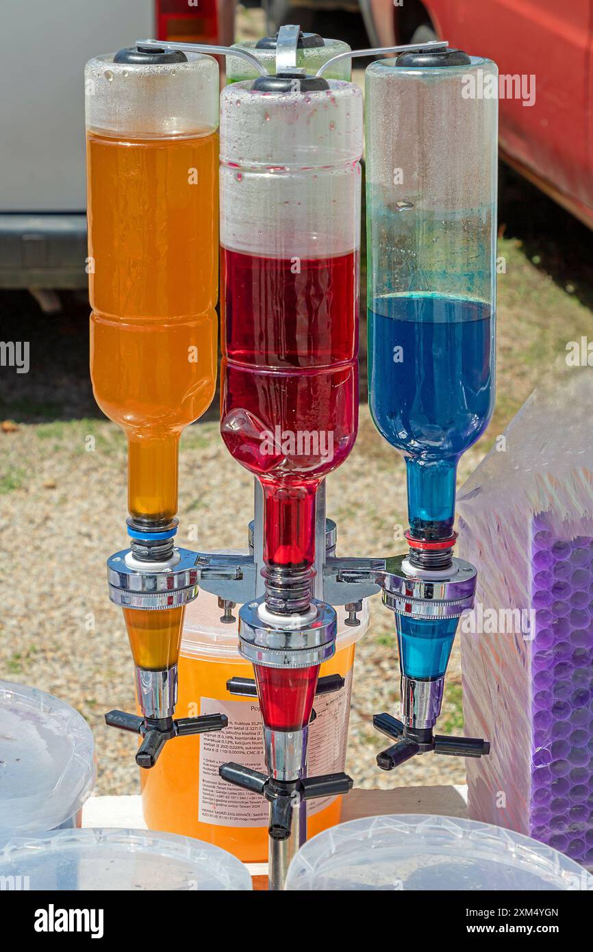 Bottles of flavours dispensers hanging above market stall Stock Photo ...