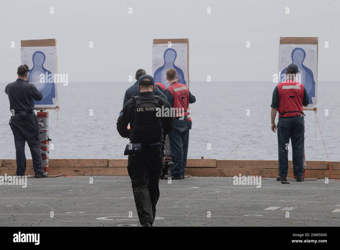 Sailors fire M9 service pistols during a small arms live-fire exercise ...