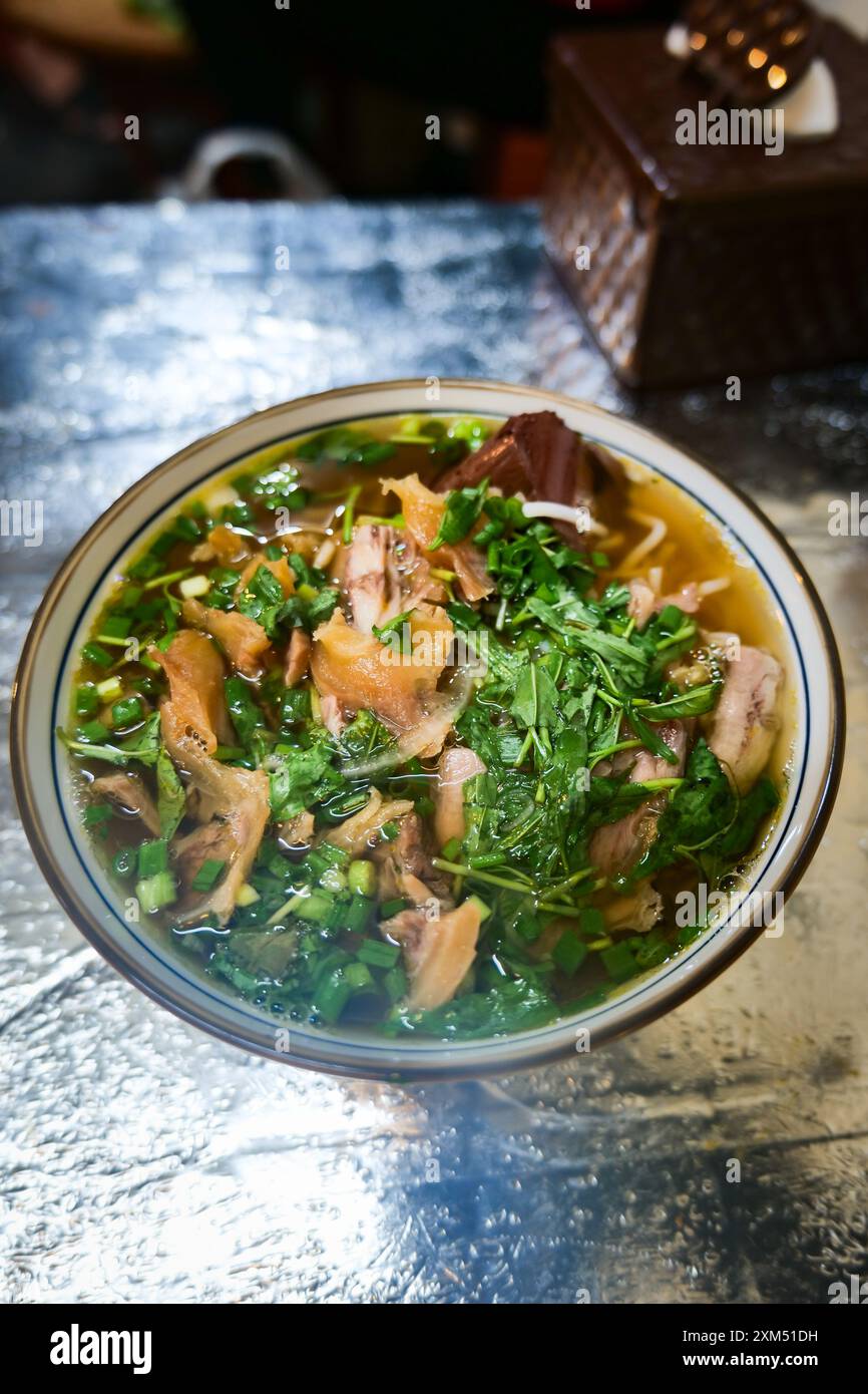 Bun Bo Hue, a popular Vietnamese noodle dish at street food stall in ...