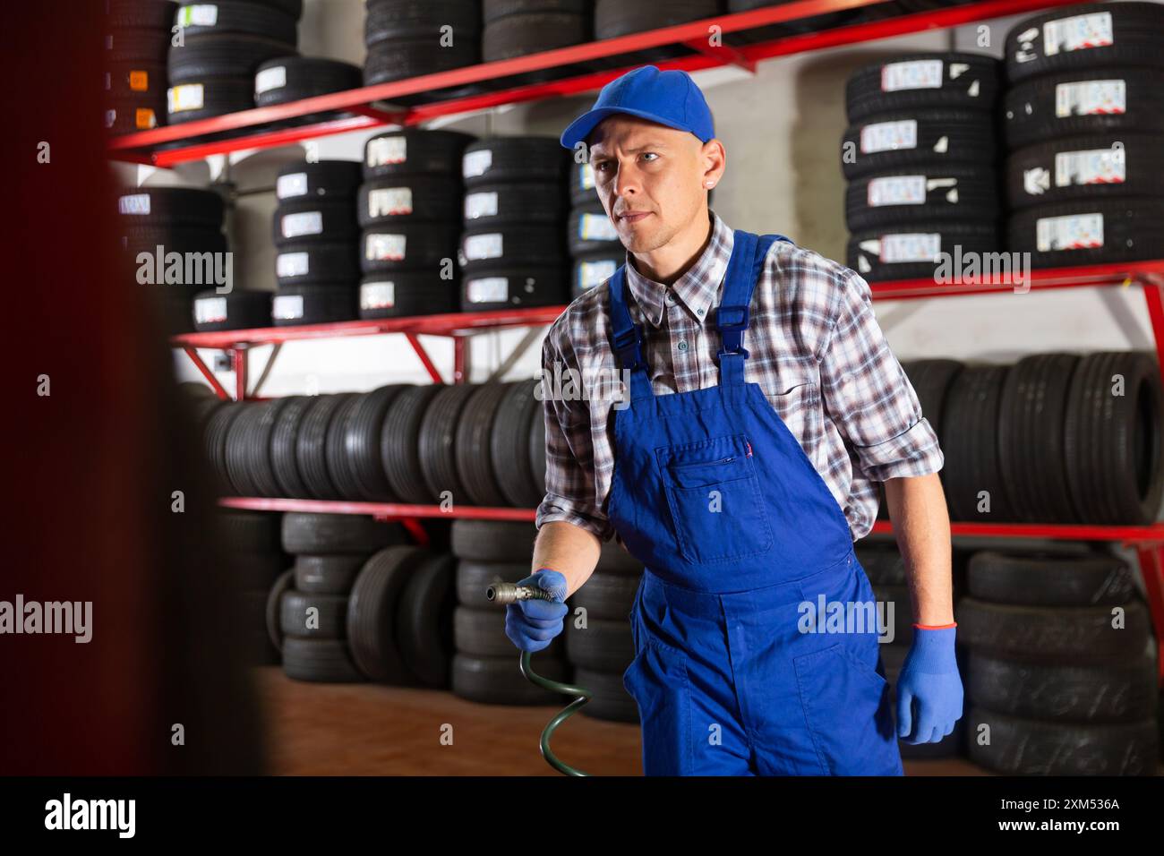 Auto mechanic with a compressor hose in hands in car service Stock ...