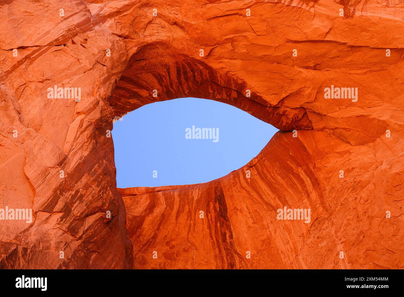 Orange sandstone rock detail of Eye of the Sun feature with blue from ...