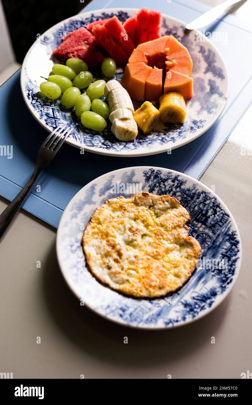 Morning food with fried egg papaya watermelon grape and bananas inside ...