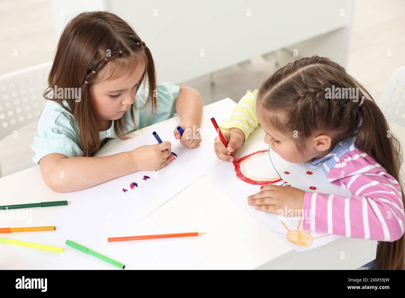 Cute little children drawing at table indoors Stock Photo - Alamy