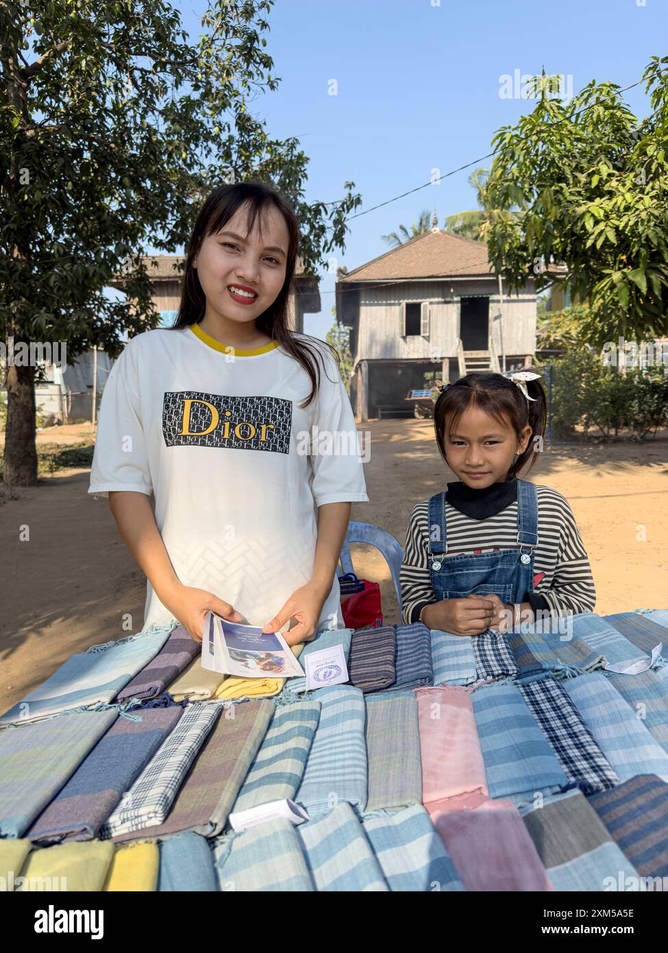 Two Young Girls Selling Hand Made Scarves In The Small Village Of