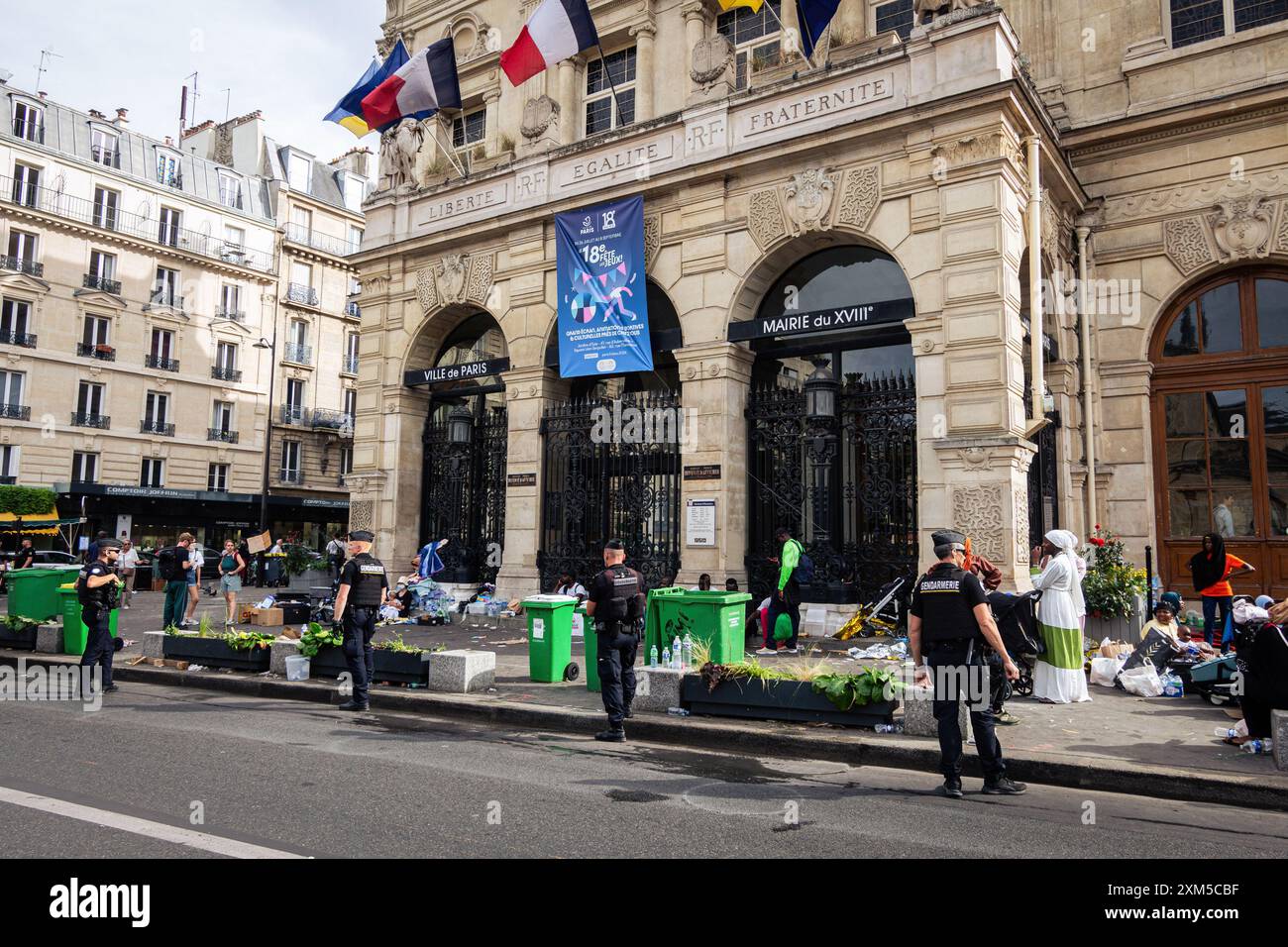 Police officers form a security perimeter in front of the 18th arrondissement Town Hall, while ...