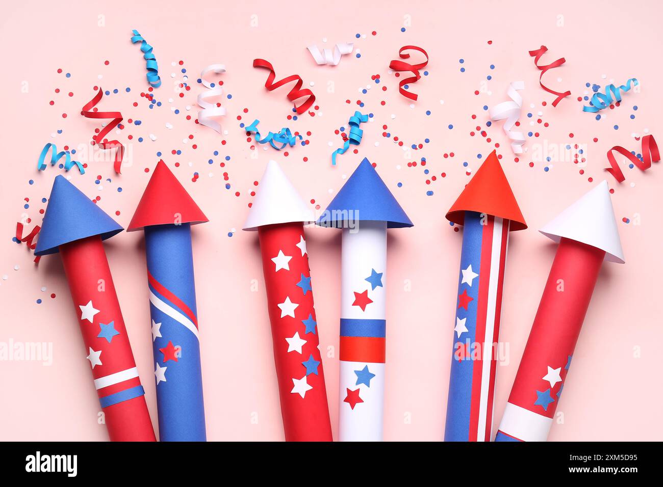 Firework rockets, confetti and serpentine for Independence Day on pink ...