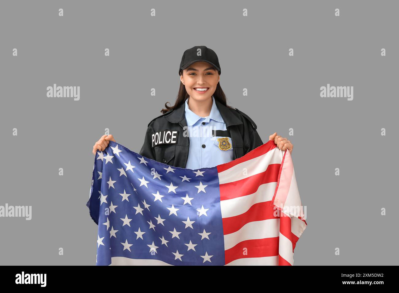 Female police officer with flag of USA on grey background Stock Photo ...