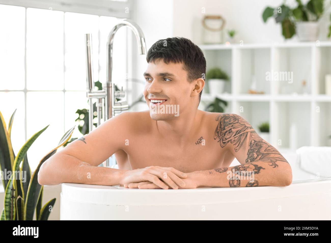 Handsome young man taking bath at home Stock Photo - Alamy