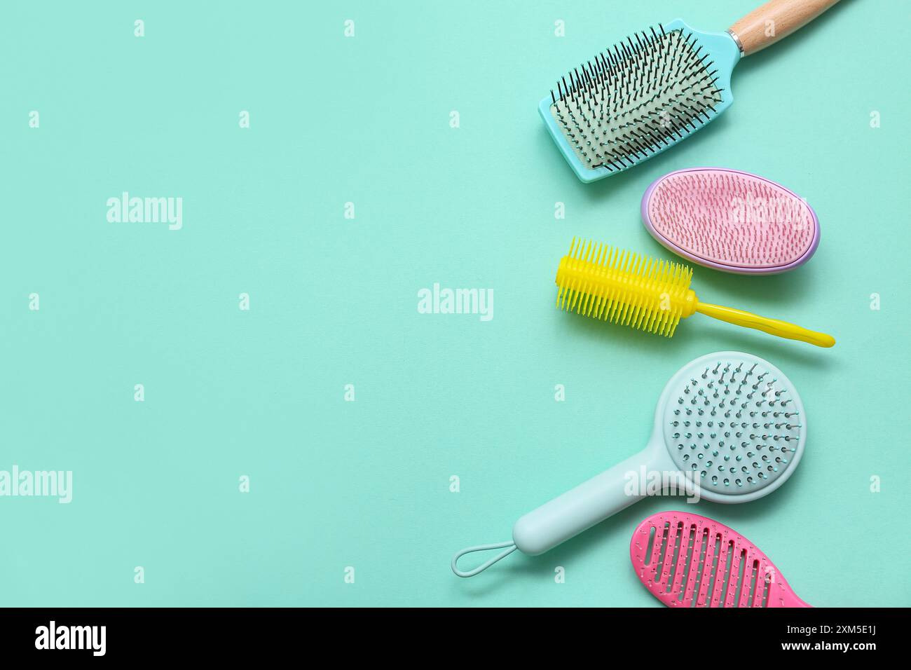 Different hair brushes on turquoise background Stock Photo - Alamy