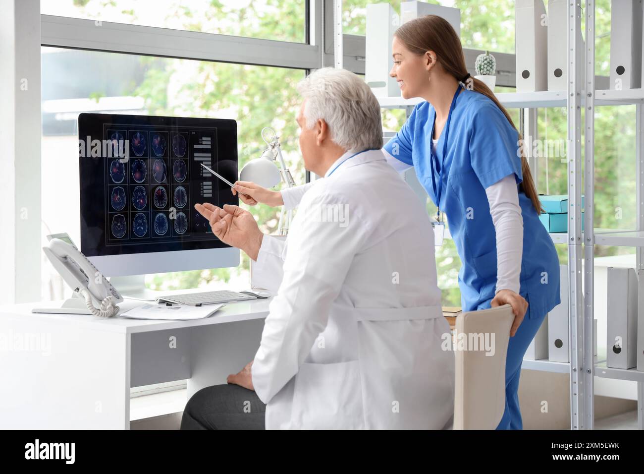 Happy doctor examining scan in hi-res stock photography and images - Alamy