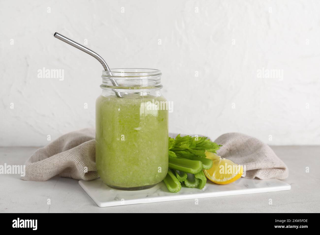 Jar of celery juice with straw, celery and lemon on white background ...