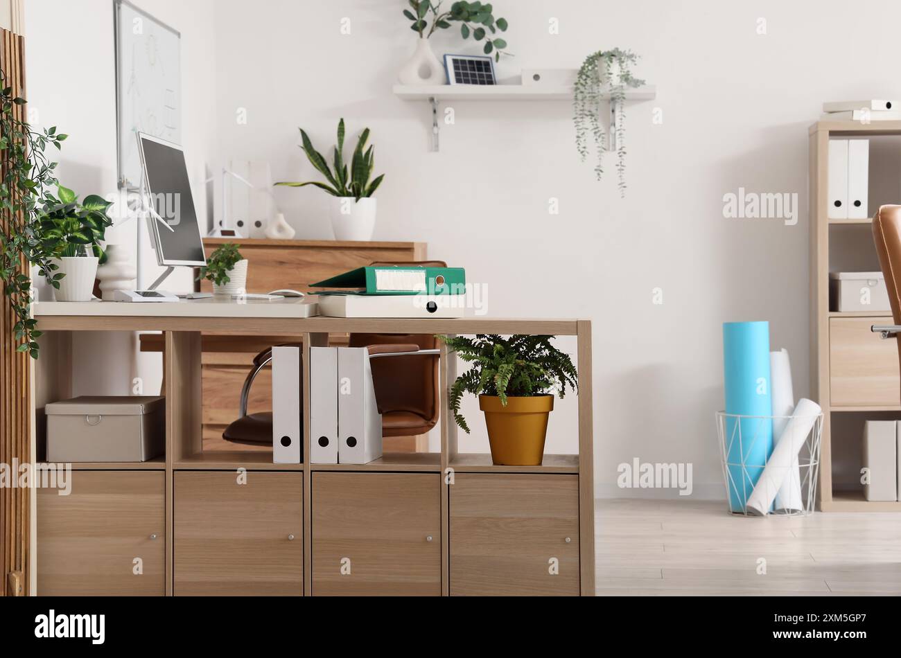 Interior of engineer's office with shelf unit, plants and wind turbine ...
