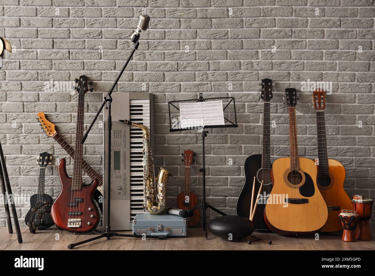Different musical instruments near grey brick wall Stock Photo - Alamy