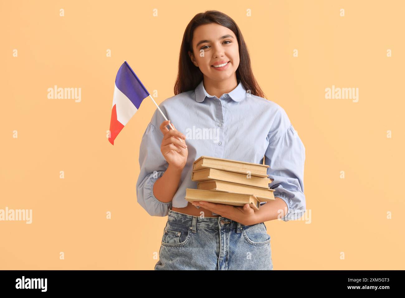 Female French language teacher with books and flag on yellow background ...