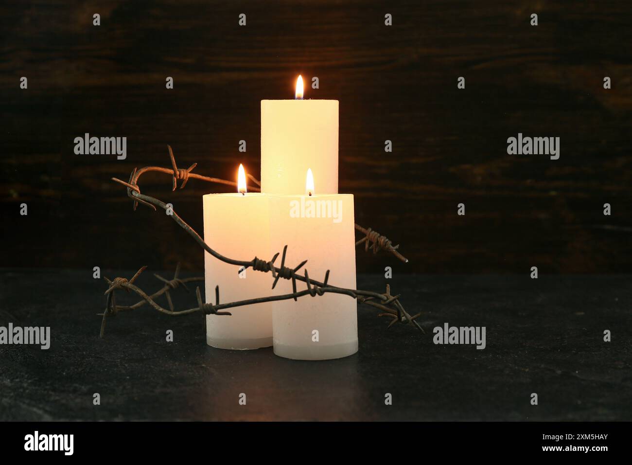 Burning candles with barbed wire on dark background. Day of Remembrance ...