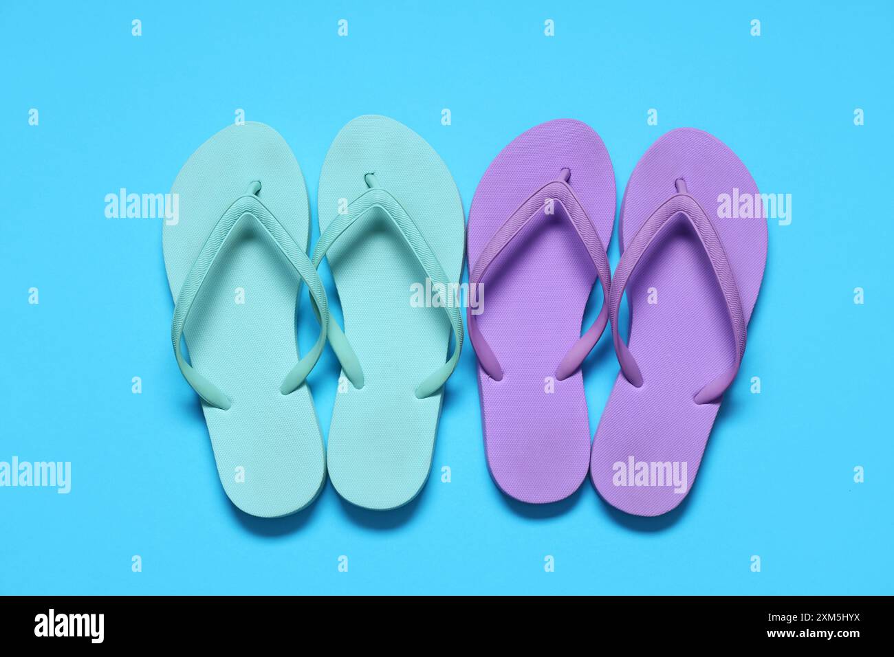Different stylish flip-flops on blue background Stock Photo - Alamy