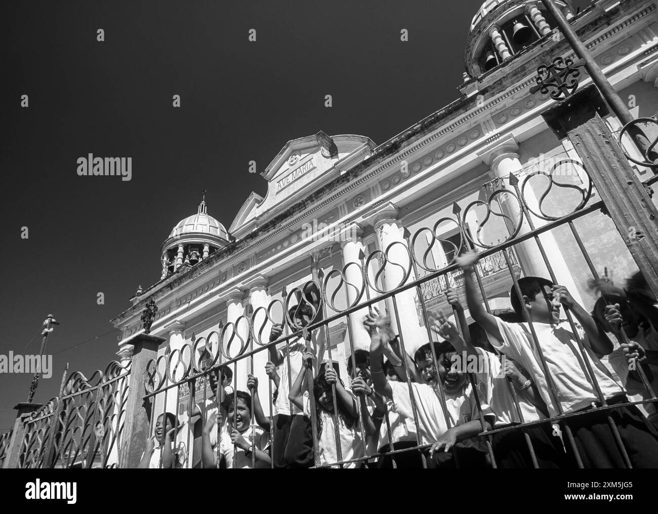 Children by fence with the Parroqia Divina Pastora Church in the ...