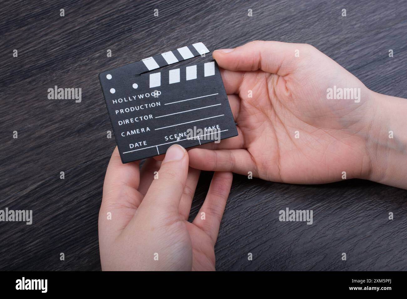 Hand holding movie clapper on a dark background Stock Photo - Alamy