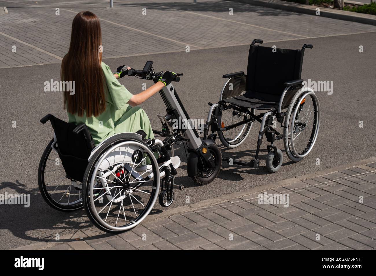 Woman in wheelchair with assistive device for manual control next to ...