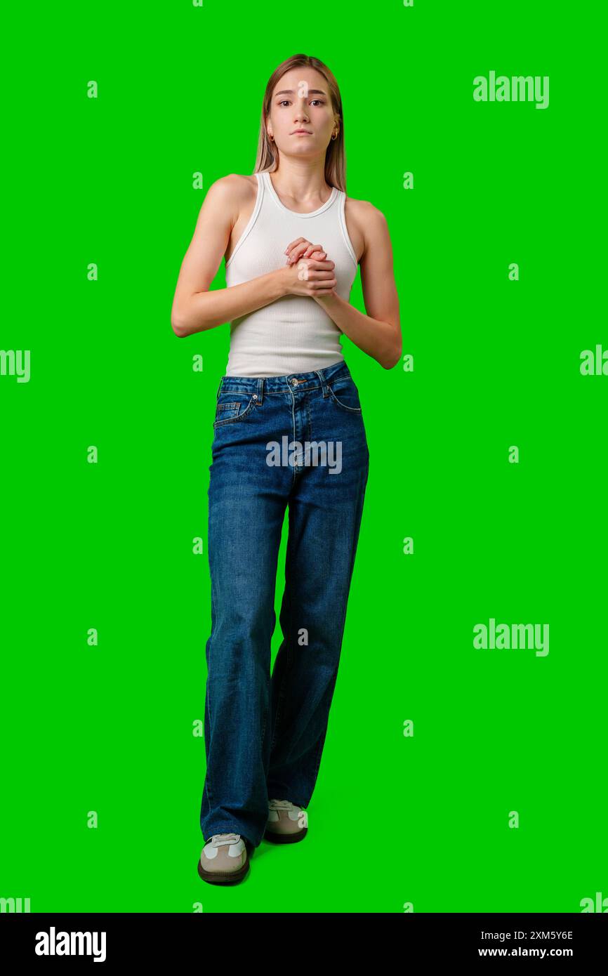 Young Woman Wearing White Tank Top and Blue Jeans Standing in Front of ...