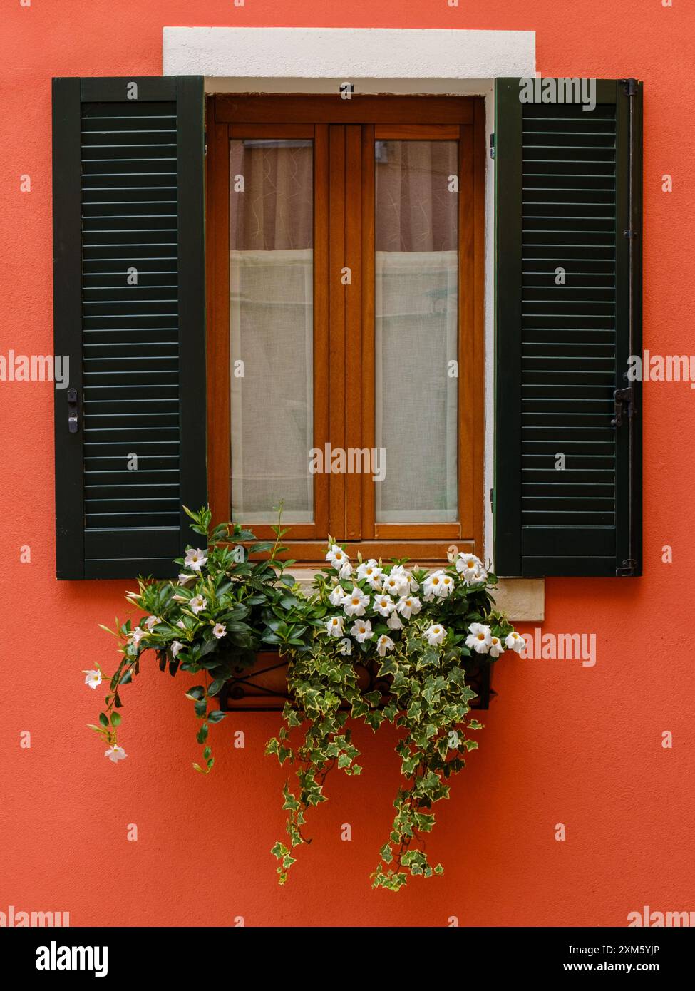 The striking dark orange window stands out against Burano's colorful ...