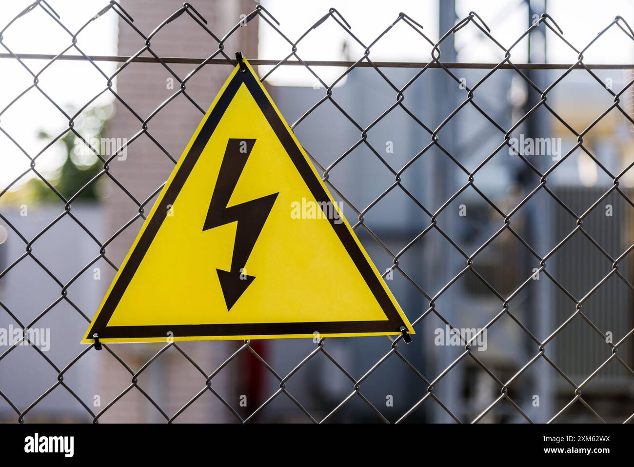 Close-up Of A Yellow High Voltage Caution Sign Hanging On Chain Fence ...
