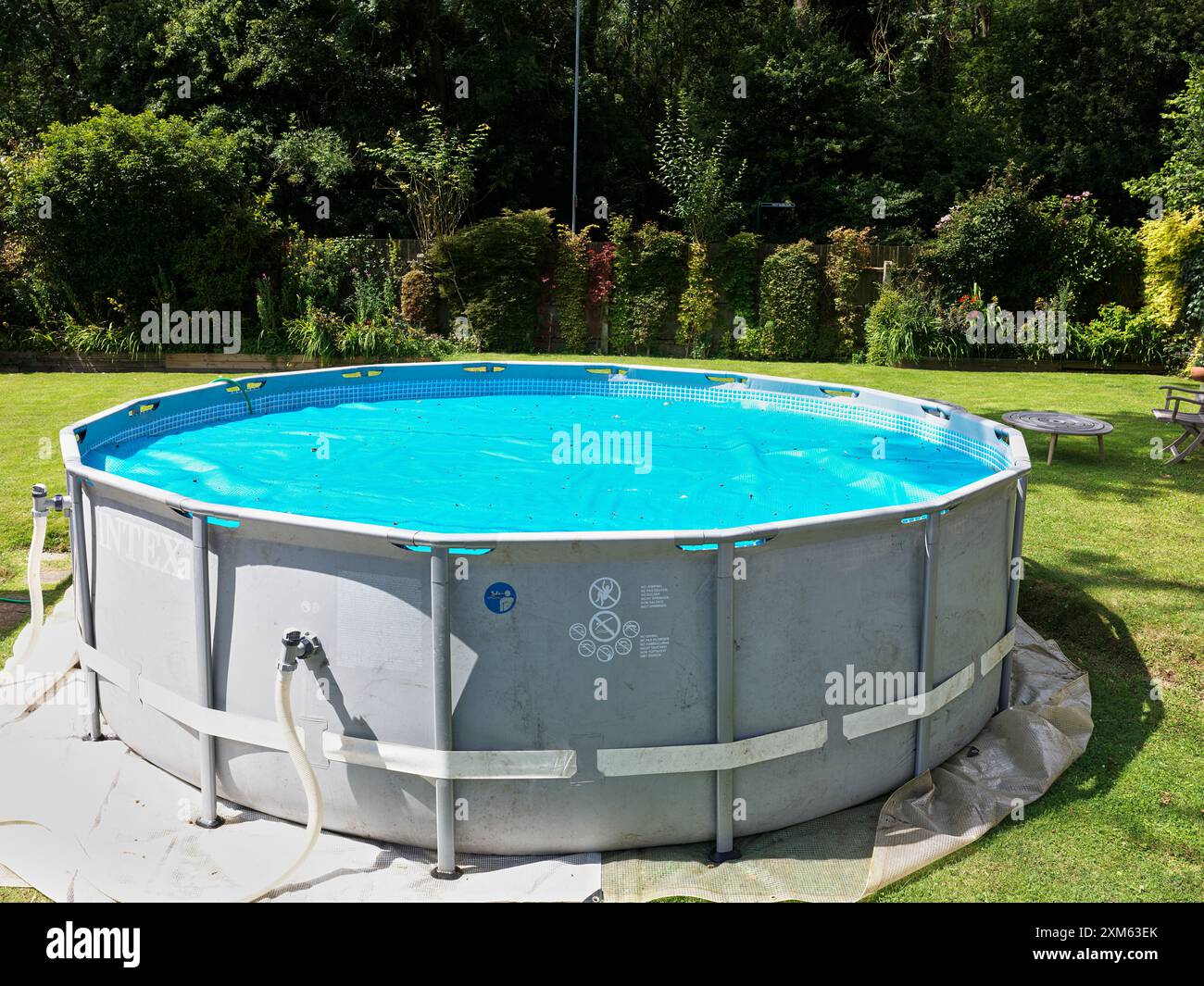 An above ground pool in an english back garden on a sunny summer day ...