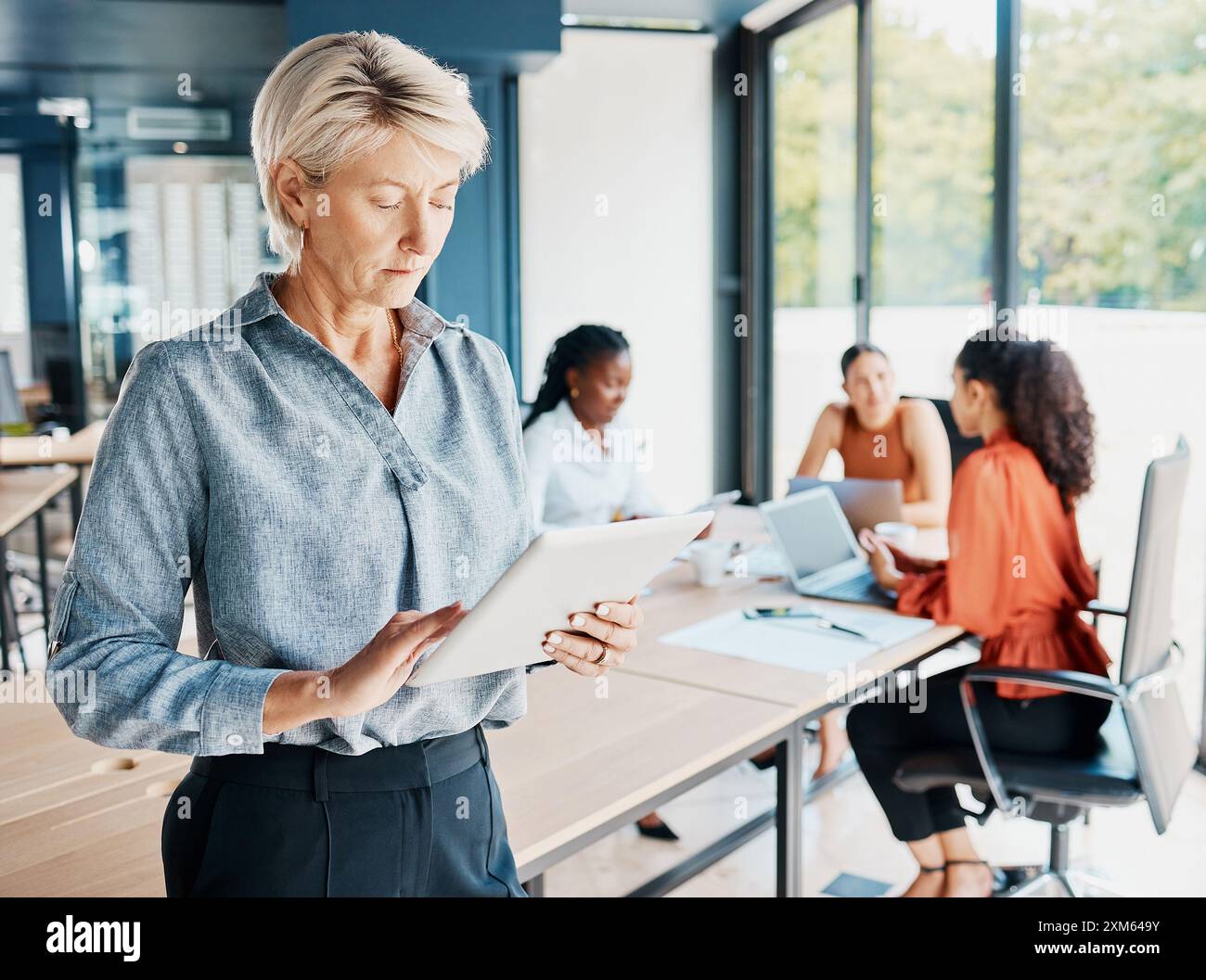 Reading, serious and mature woman with tablet, office and research of ...