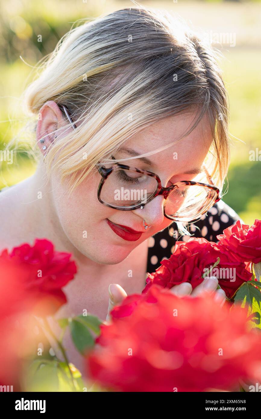 A blond woman in a black dress with white polka dots enjoys the summer ...