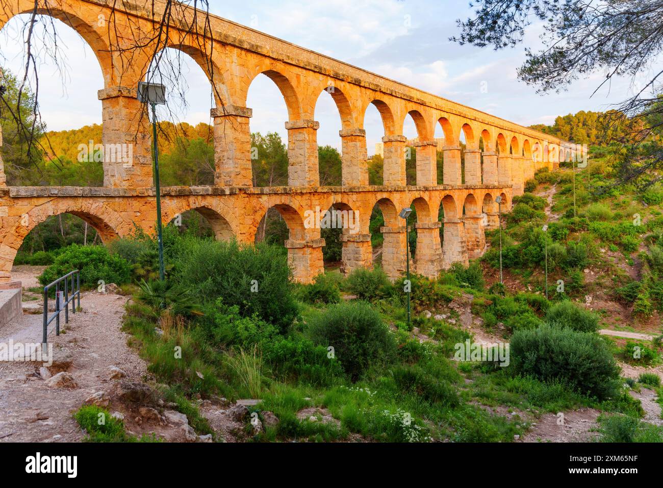 Stunning view of Roman aqueduct known as Devil's Bridge in Tarragona bathed in golden light at ...