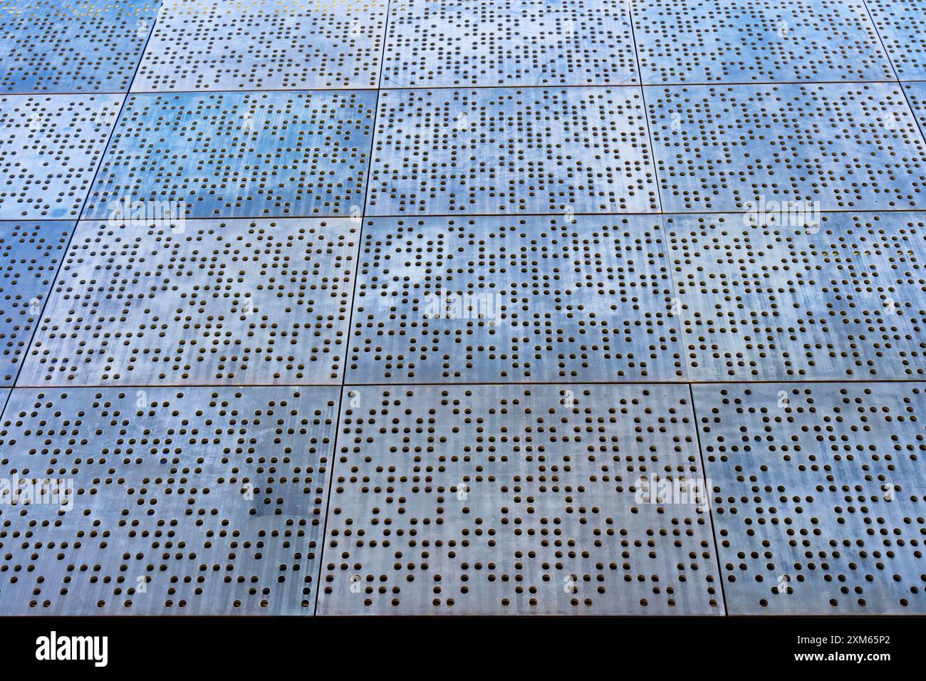 Top-down view of a textured perforated metal wall exhibiting an ...
