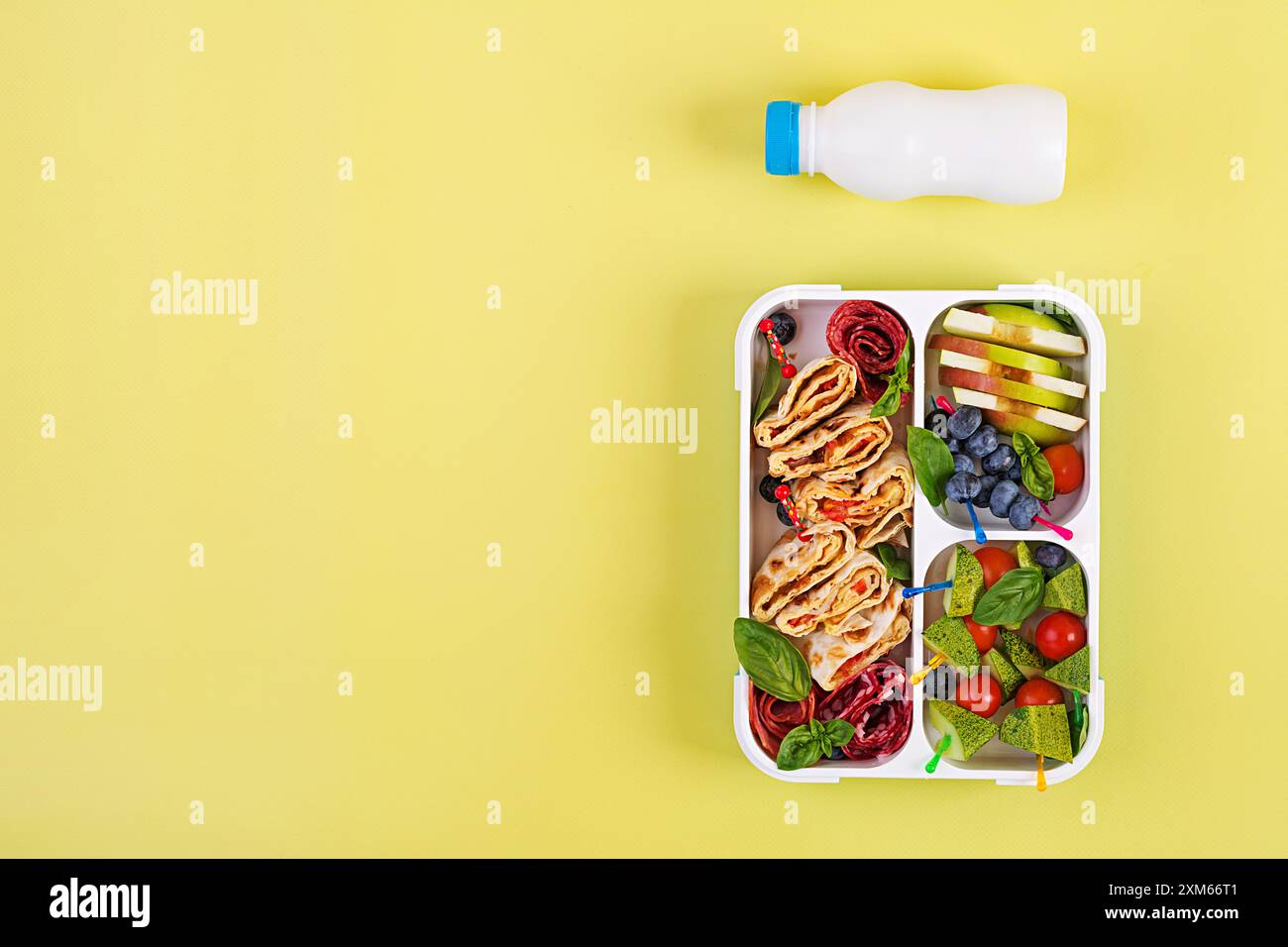 Kids lunch box with tortilla roll, sausage, cherry tomatoes and ...