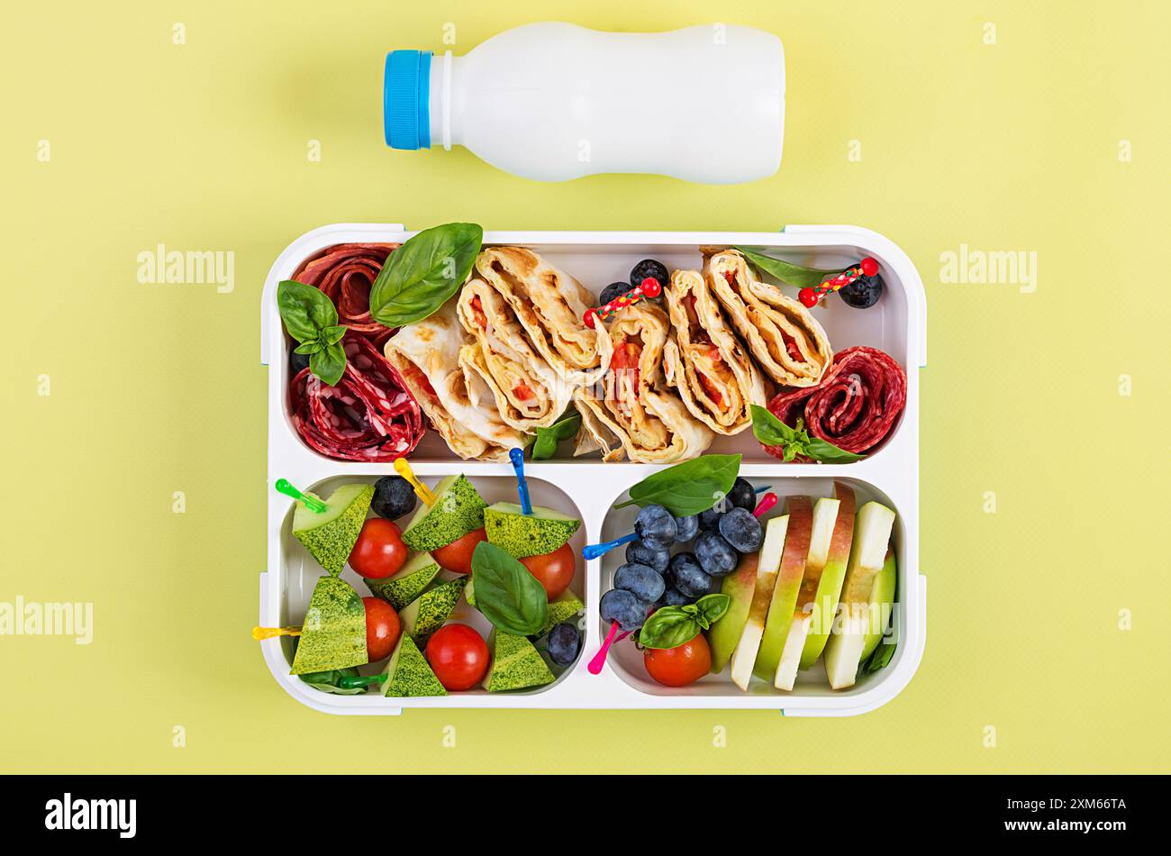 Kids lunch box with tortilla roll, sausage, cherry tomatoes and ...