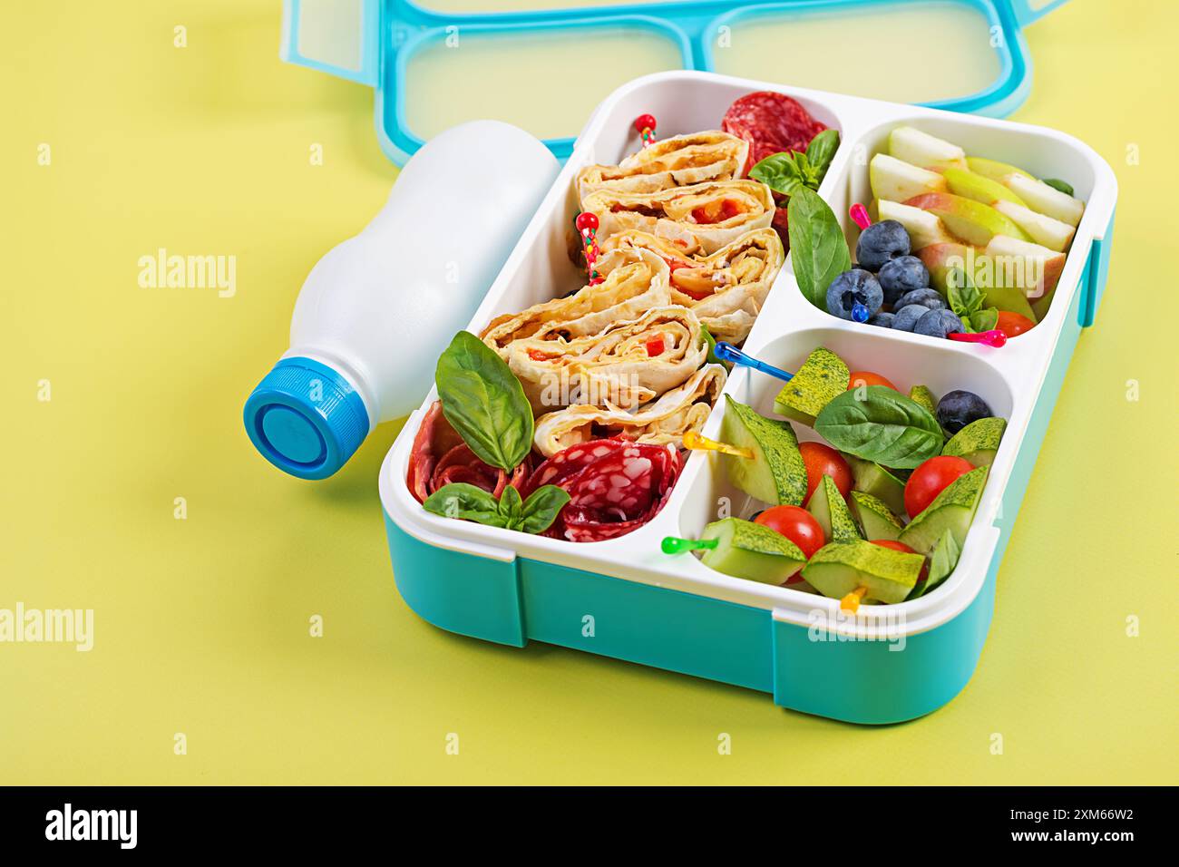 Kids lunch box with tortilla roll, sausage, cherry tomatoes and ...