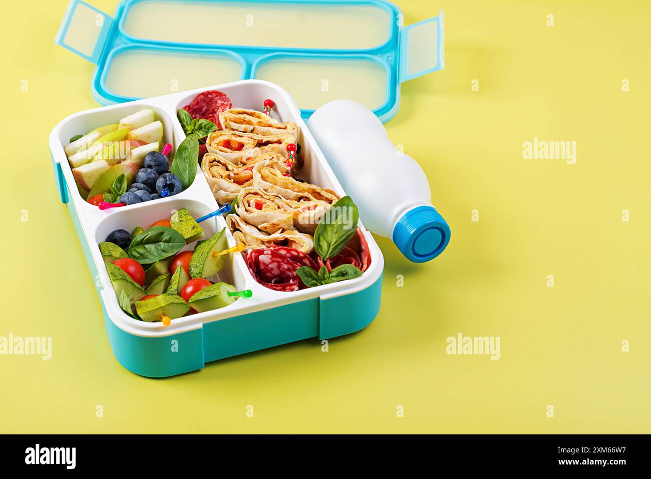 Kids lunch box with tortilla roll, sausage, cherry tomatoes and ...