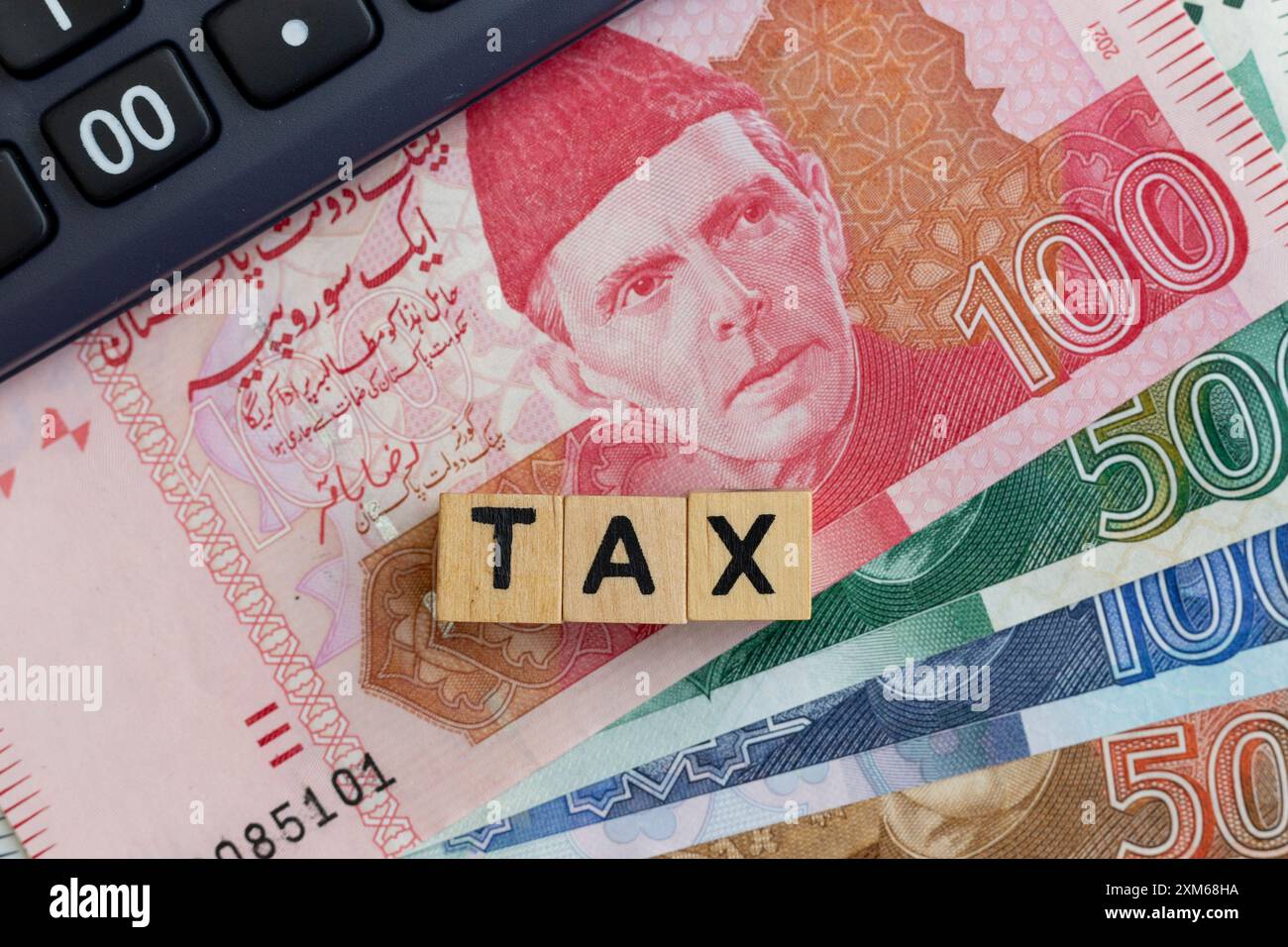 Wooden blocks TAX word on Pakistani banknotes with calculator. Tax ...