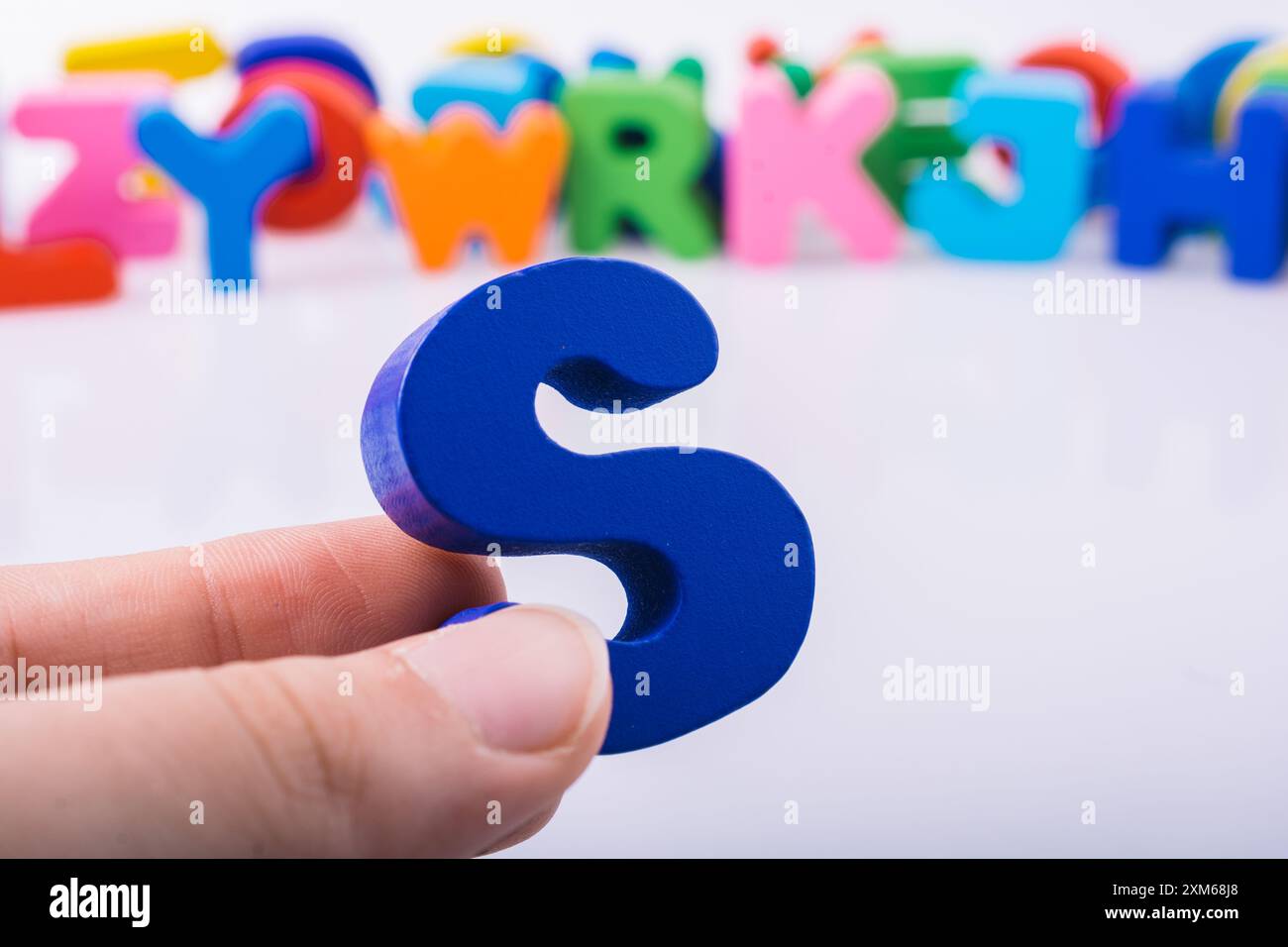 Hand holding letter cube S of made of wood Stock Photo - Alamy