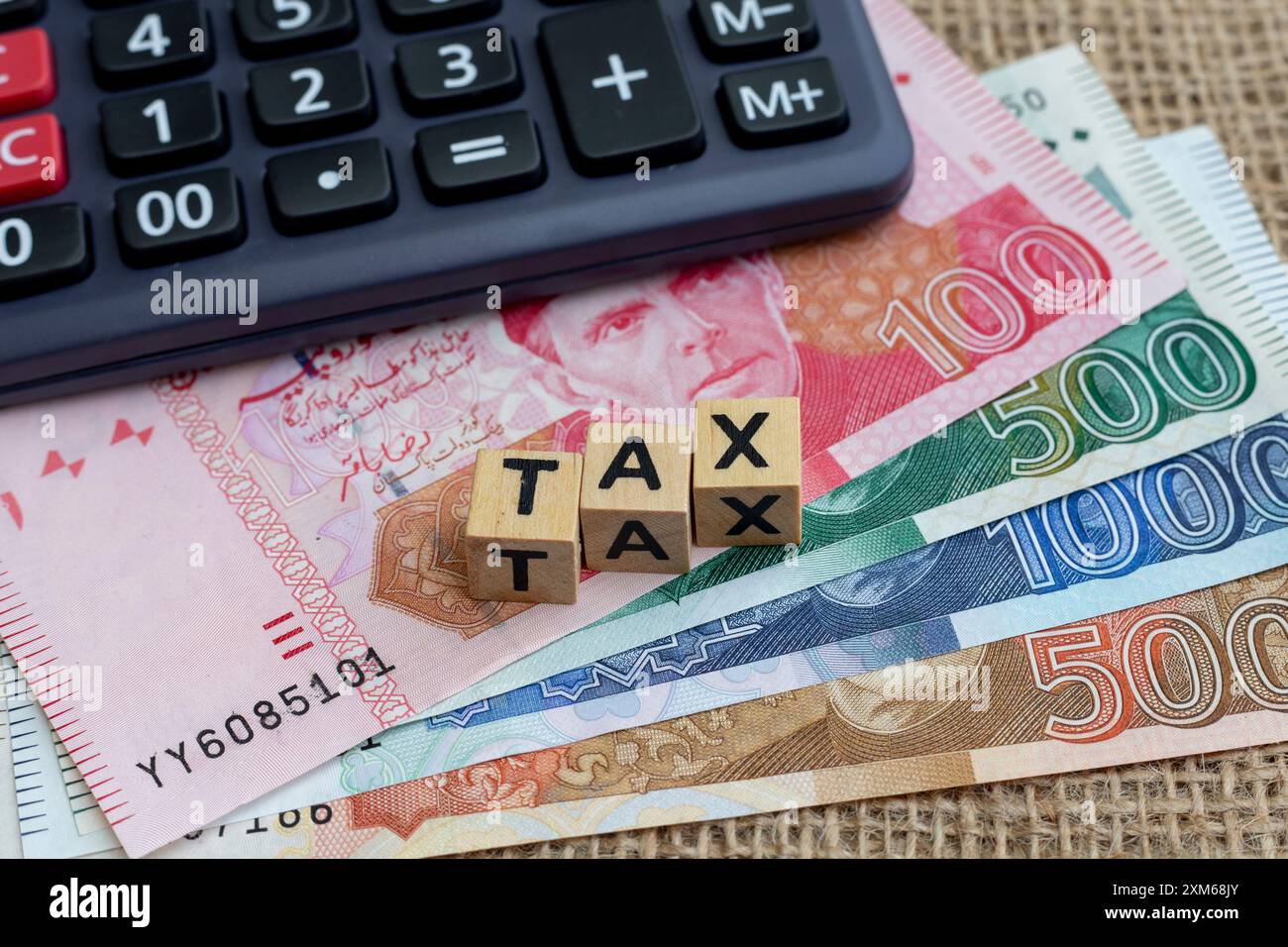 Wooden cubes with the word Tax on Pakistani rupees with calculator. Tax ...
