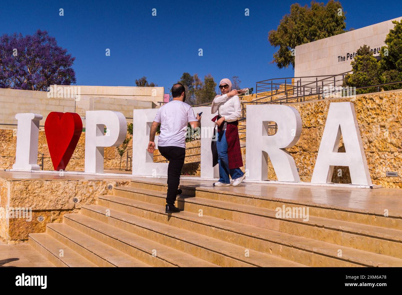 A couple posing in front of a giant PETRA sign, UNESCO World Heritage ...