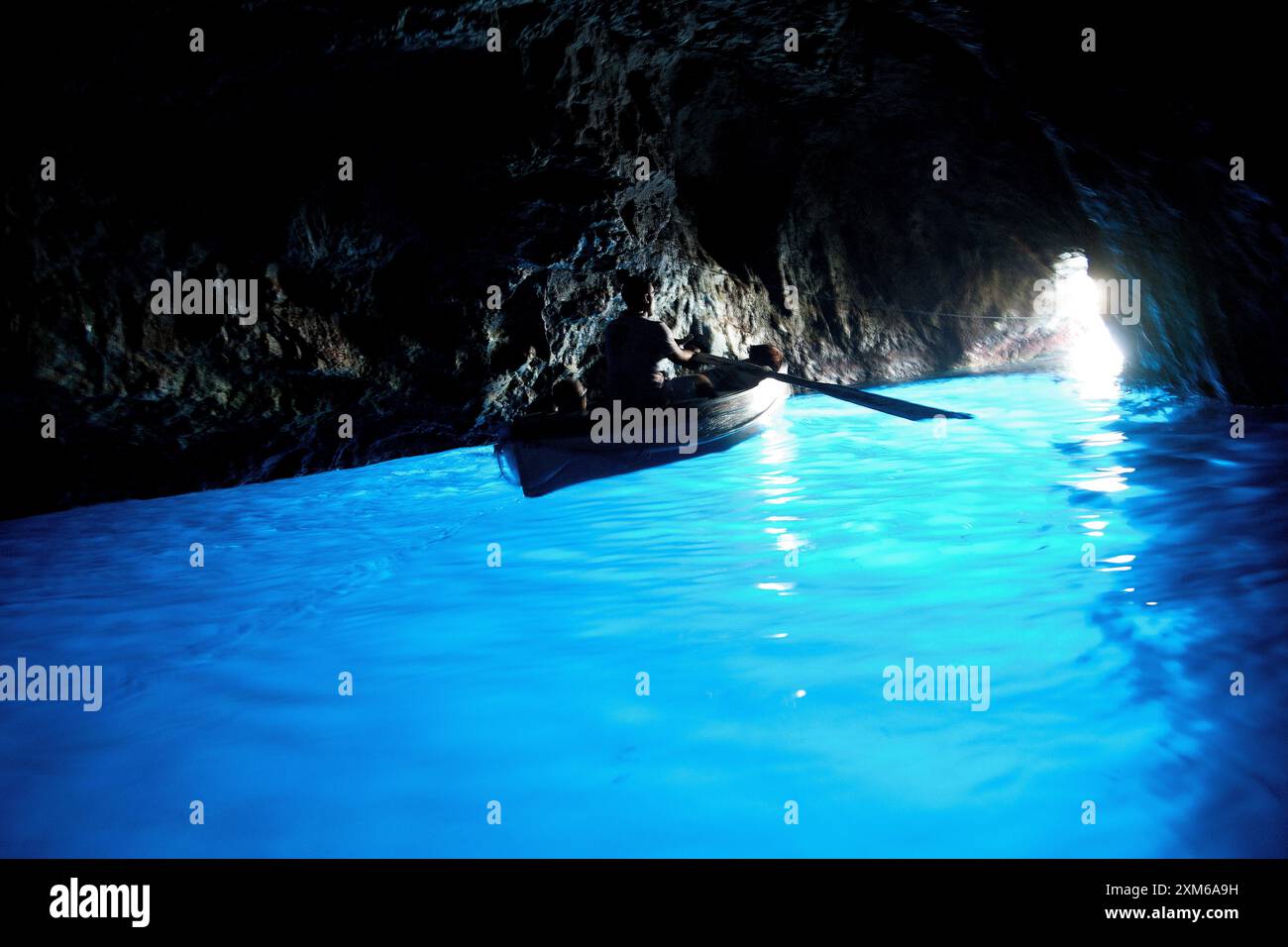 Guides in rowboats taking tourists into the Blue Grotto in Capri Italy ...