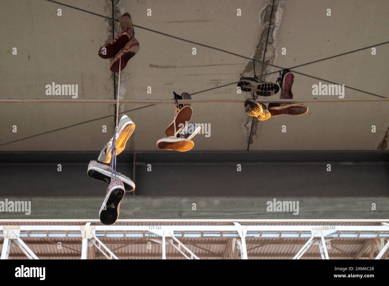 Shoes hanging high in public park. Signs and symbols Stock Photo - Alamy